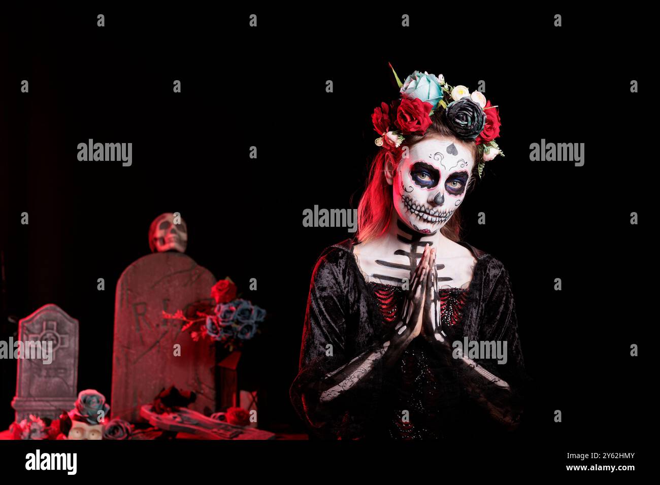 Woman doing praying hand gesture at Day of the Dead event to remember ...