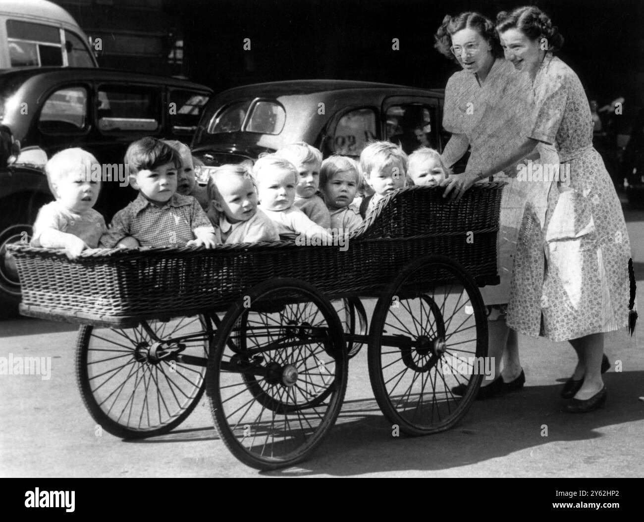 Improvised large pram; a cane basket on wheels to push a group of ...