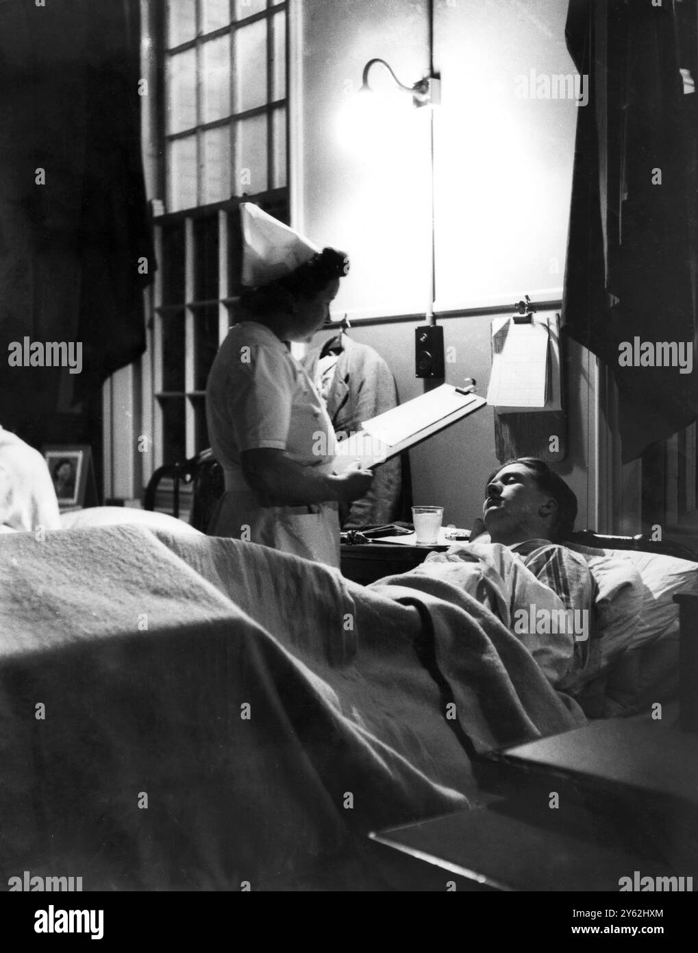 A nurse attends to a sick patient in hospital during wartime 1939 ...
