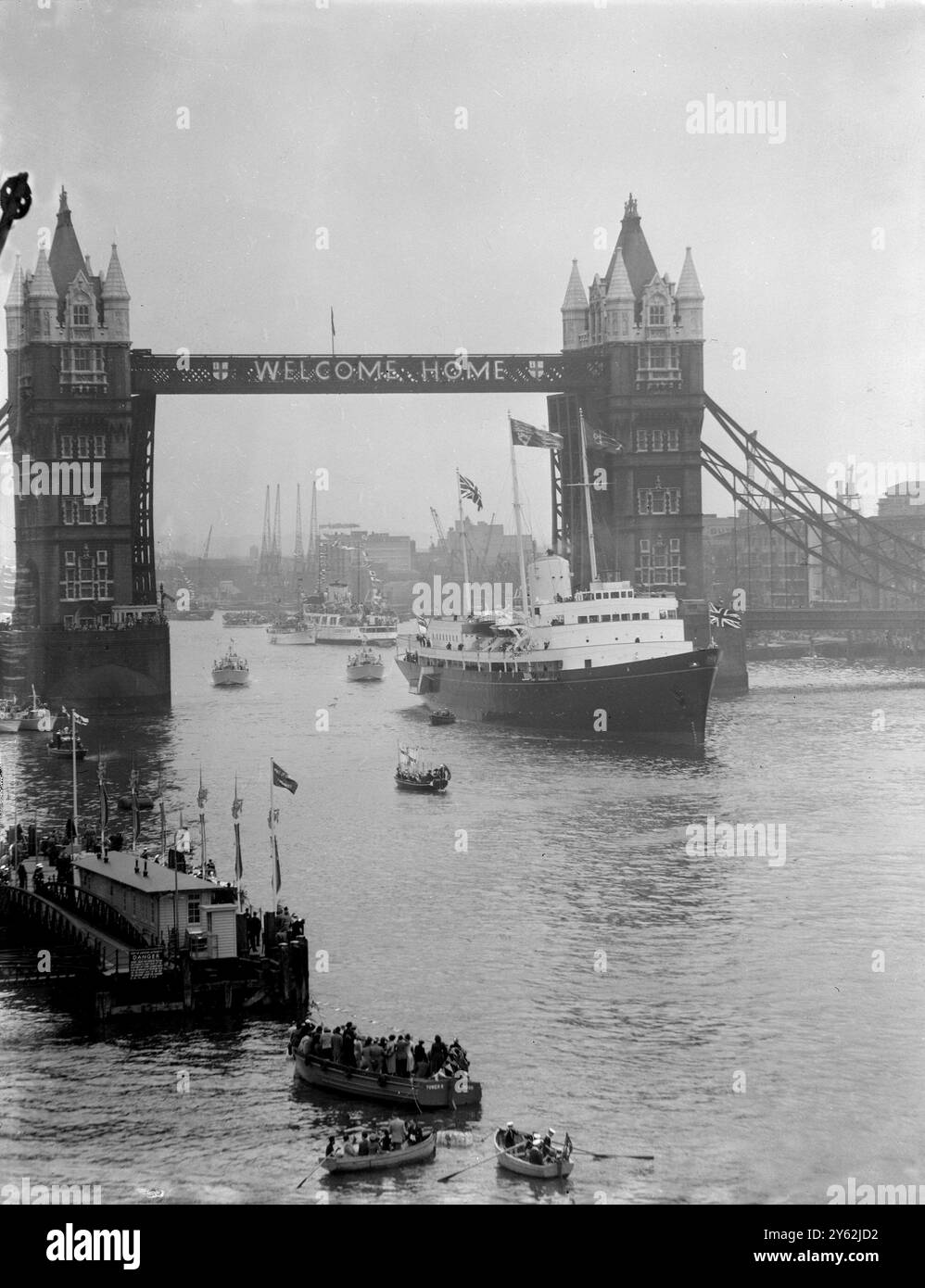 Through the welcoming Tower Bridge slowly moves the Royal Yacht ...