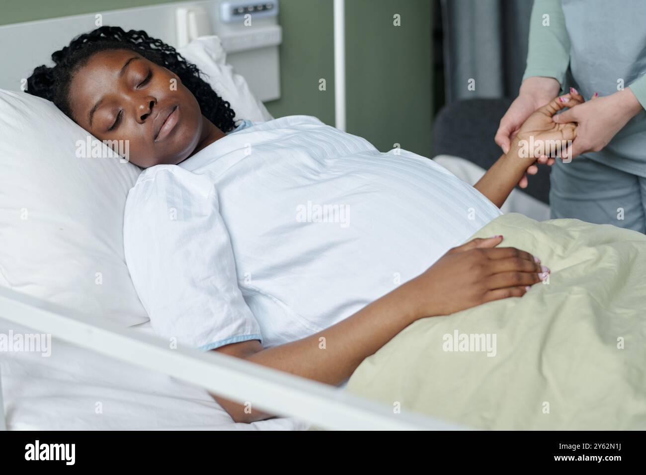 African American patient lying in hospital bed receiving emotional ...