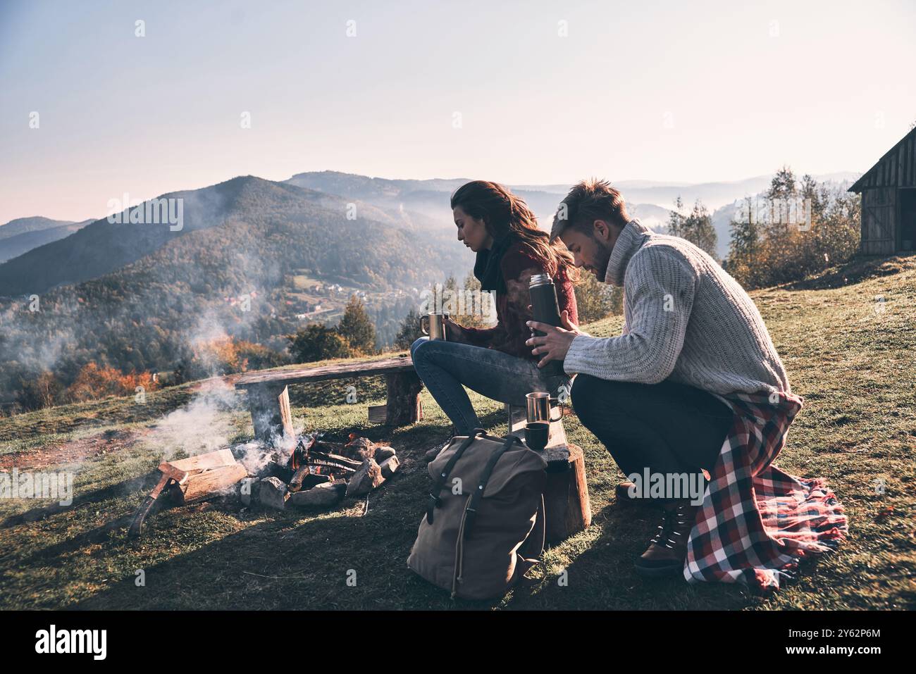Resting together. Beautiful young couple having morning coffee while ...