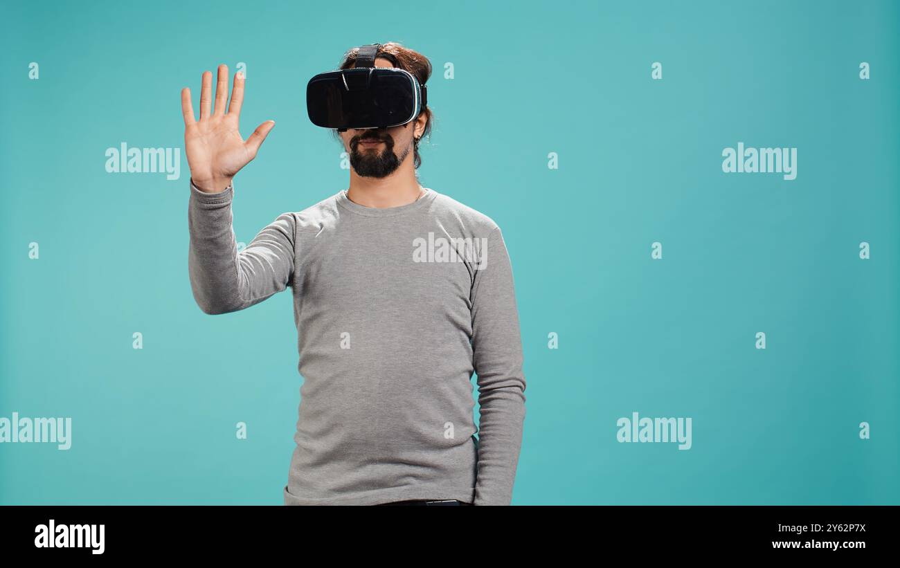 Tech enthusiast wearing virtual reality goggles, doing zooming in ...