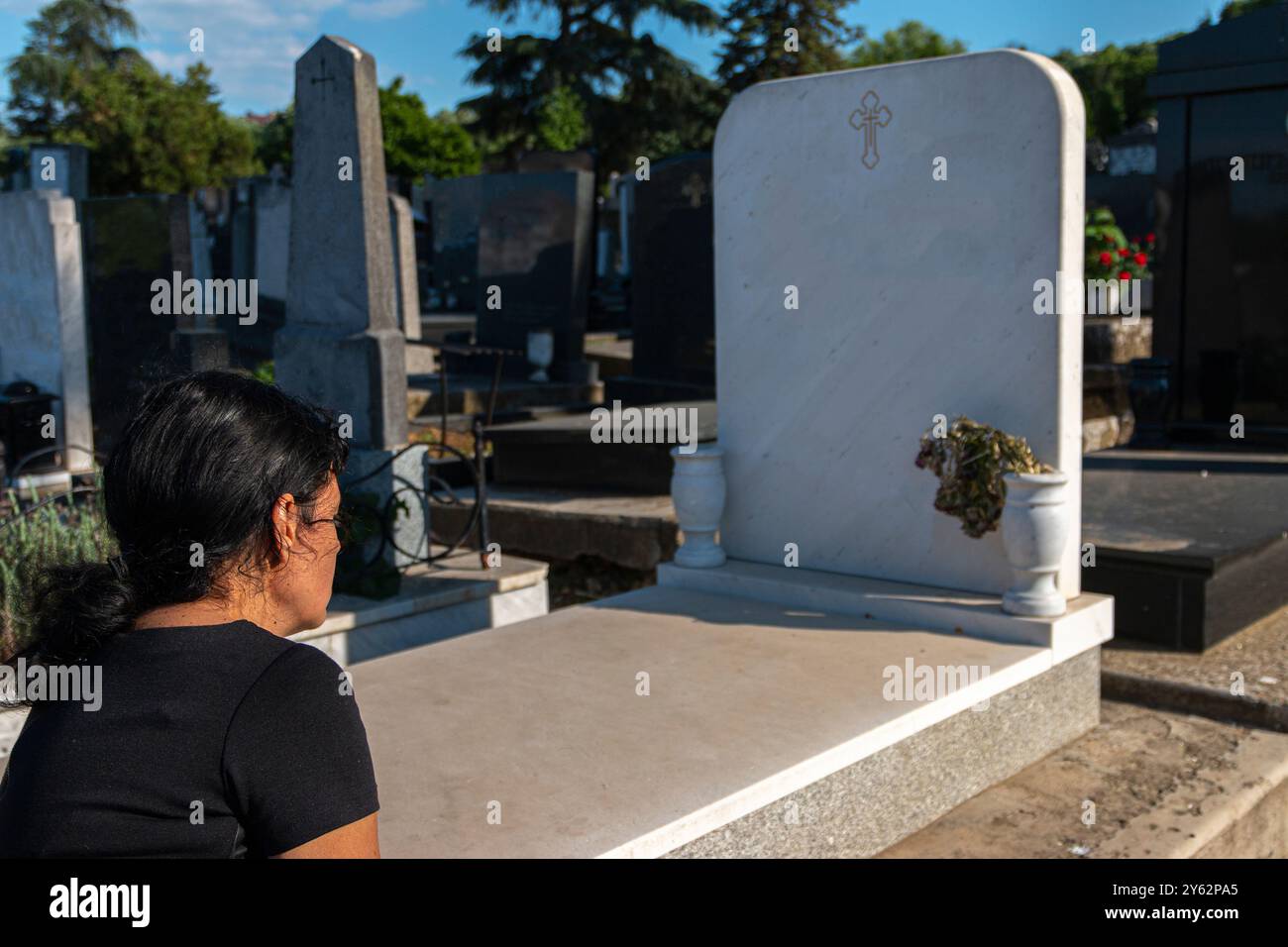 Mature woman in black clothes on cemetery and mourning for family loss ...