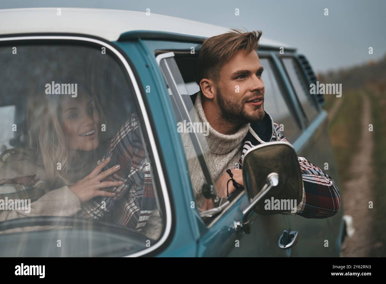 Breathtaking feelings? Handsome young man leaning out the van?s window ...