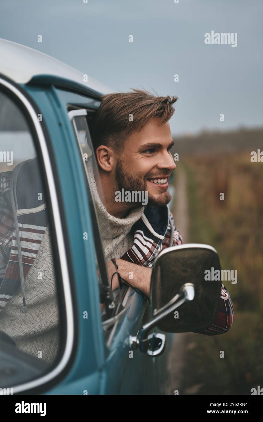 In the middle of nowhere. Handsome young man leaning out the van?s ...