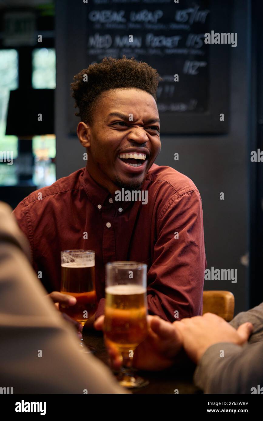 A African man laughing while hanging out with his friends Stock Photo ...
