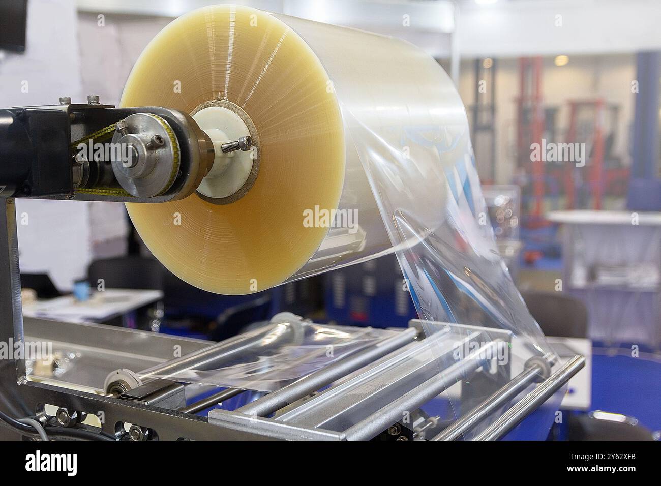 Automatic packaging machine for producing packs from a roll of heat ...