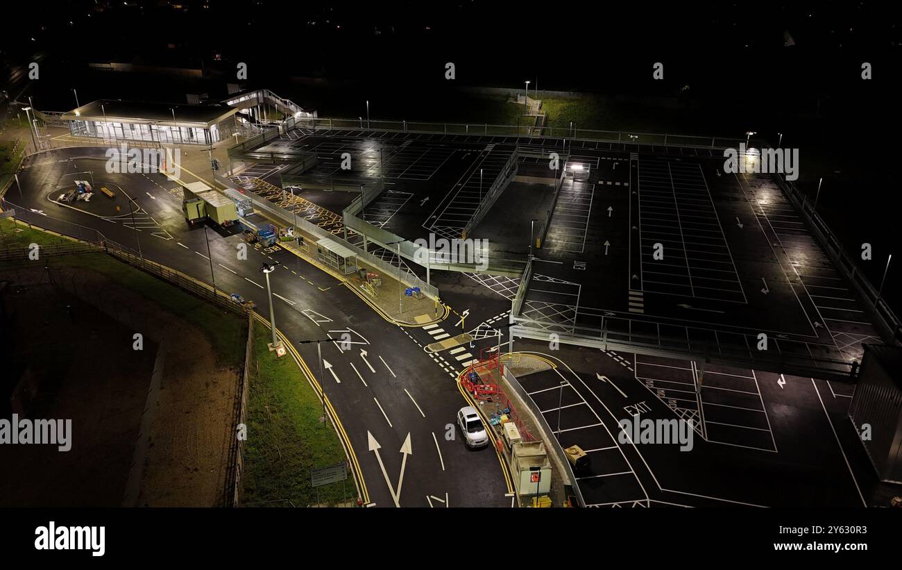 An aerial night view of a parking lot and building with illuminated ...
