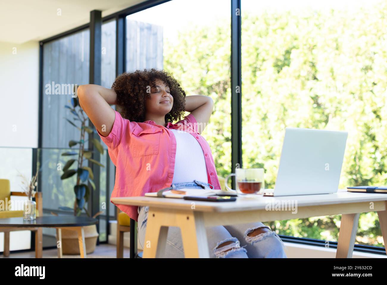 Relaxing at desk, woman with laptop and tea taking break from work ...
