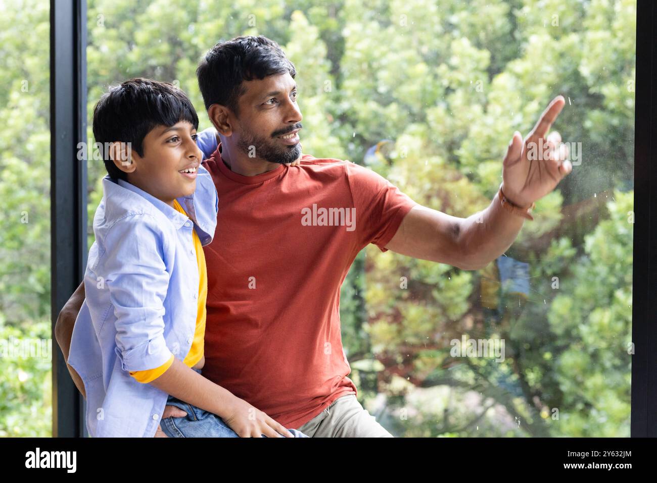 Indian father and son sitting together, Indian father pointing at ...