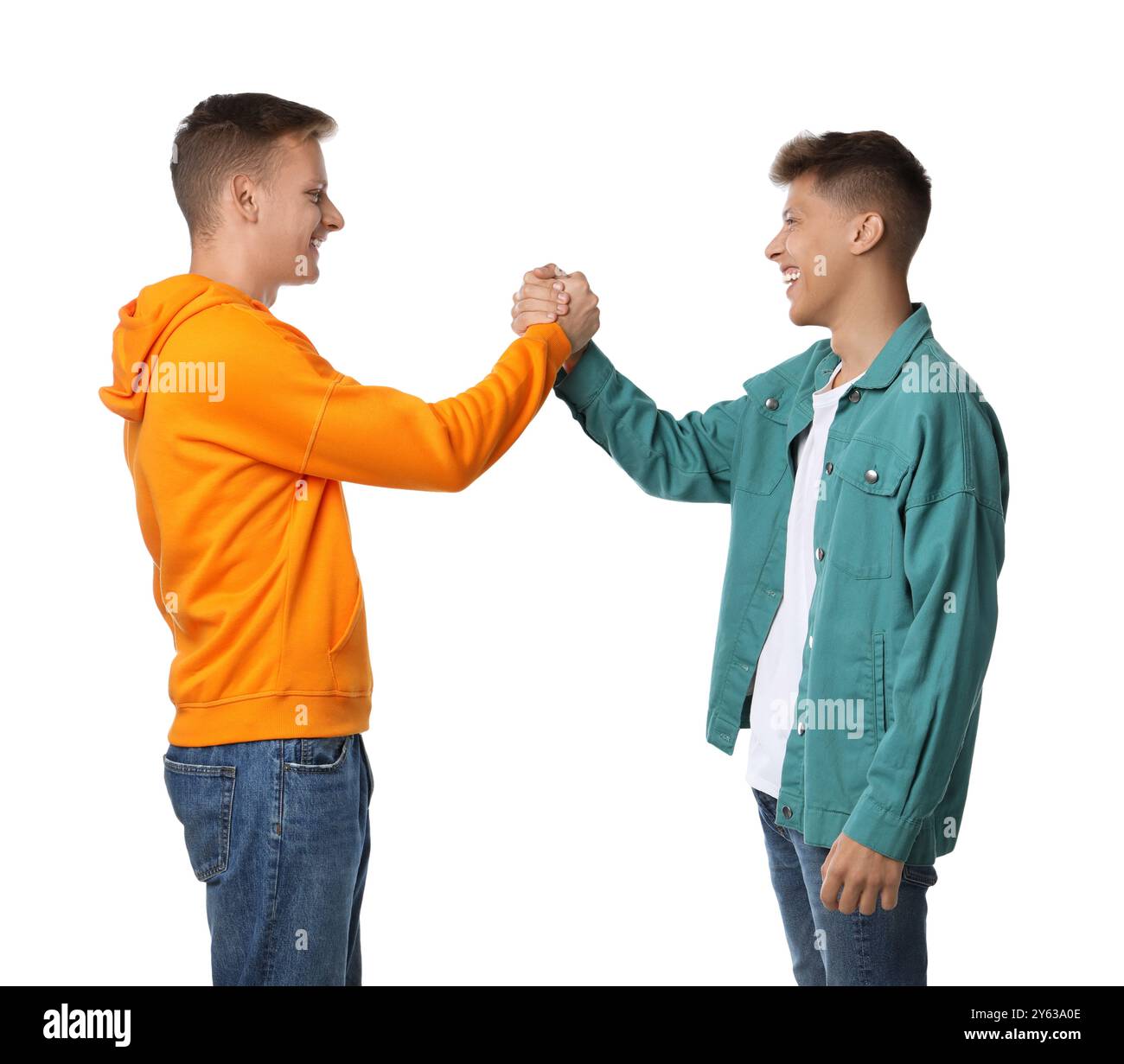 Two young brothers clasping hands on white background Stock Photo - Alamy