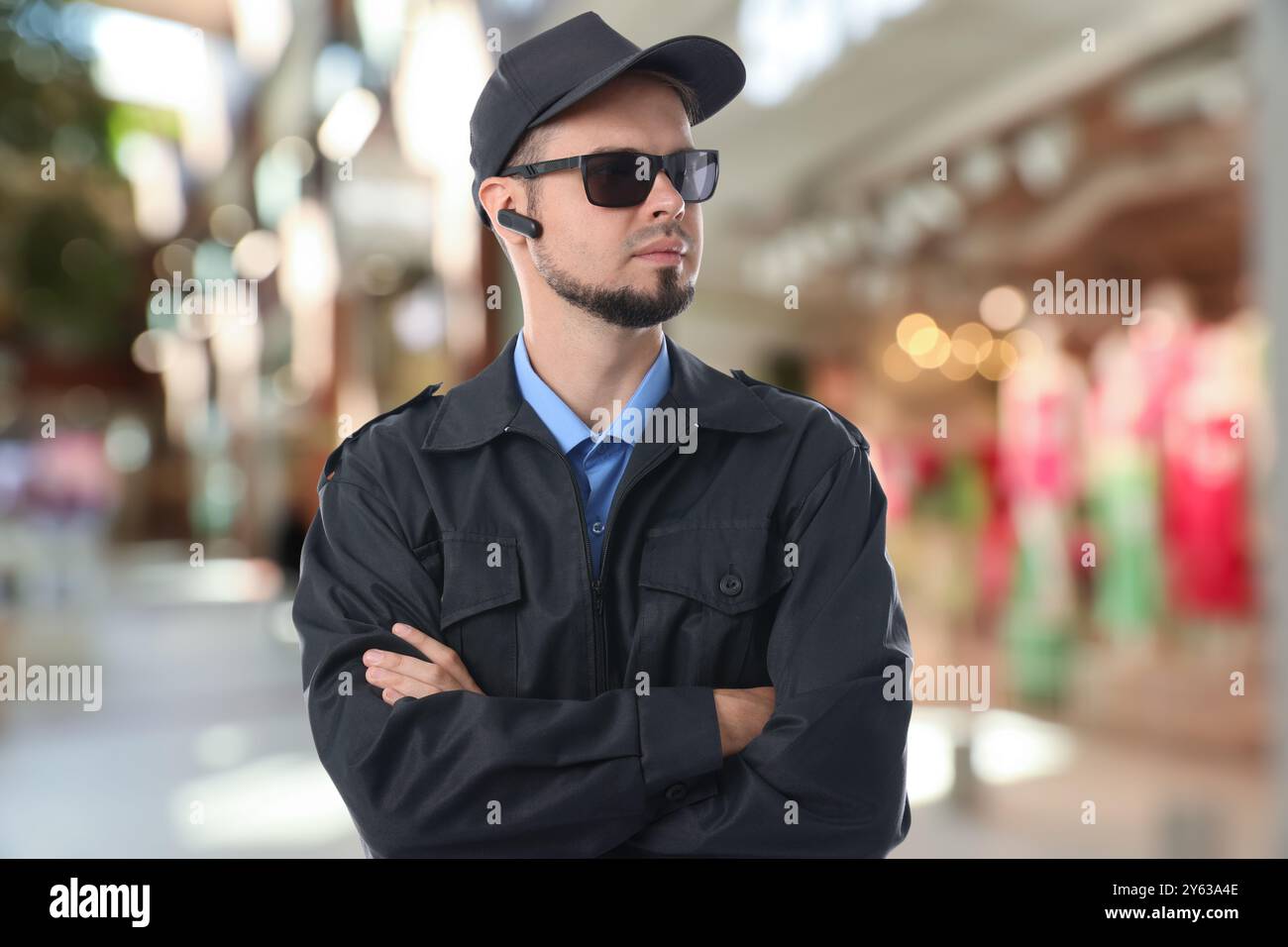 Confident security guard with earpiece in clothing store Stock Photo ...
