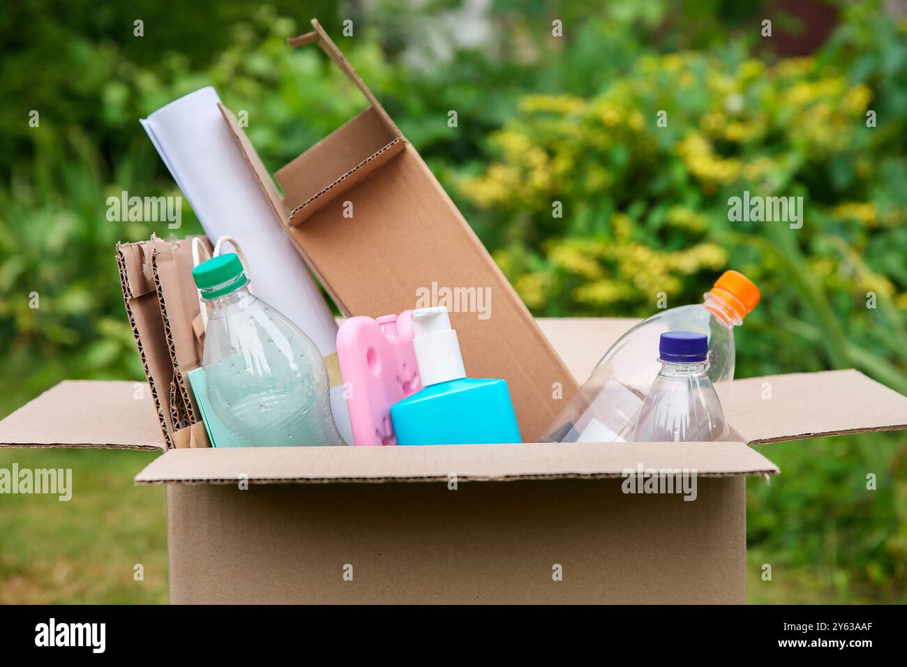 Recycling. Different garbage in cardboard box outdoors Stock Photo - Alamy