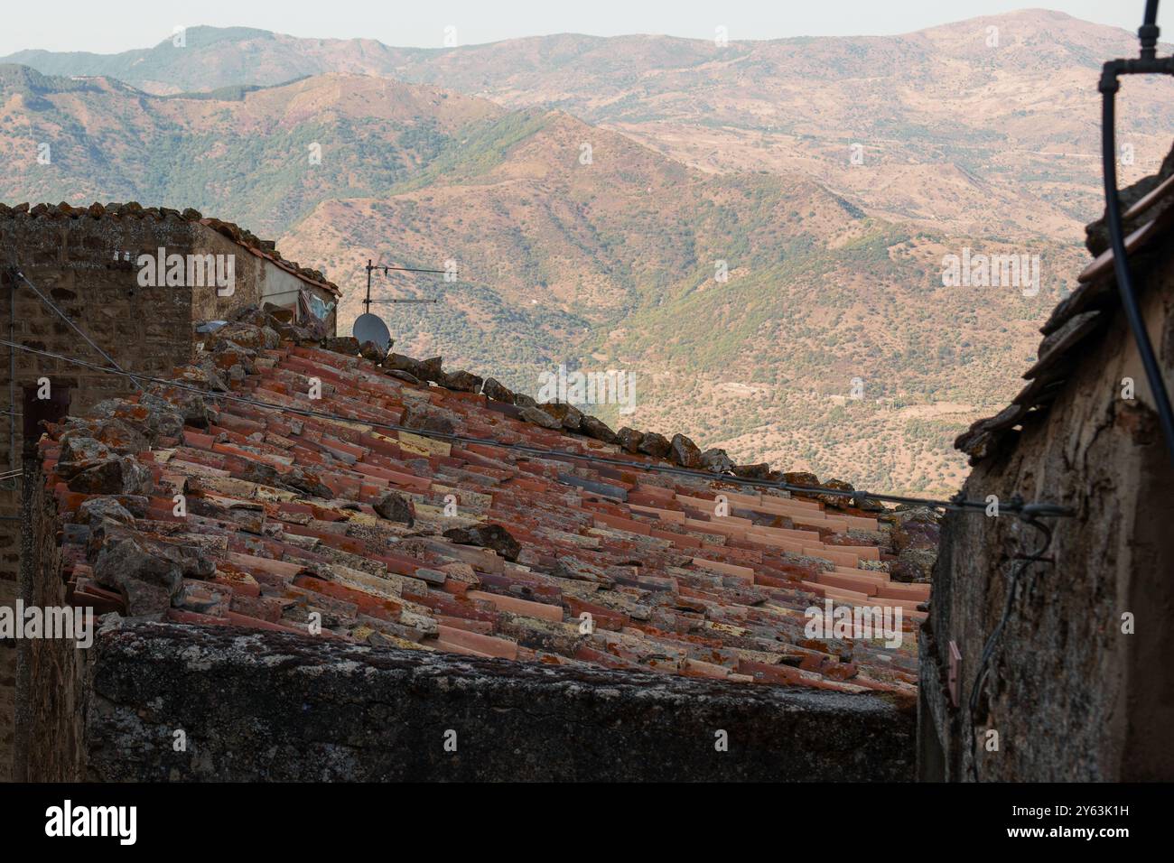 Rustic village rooftops with mountain backdrop in Mediterranean setting ...