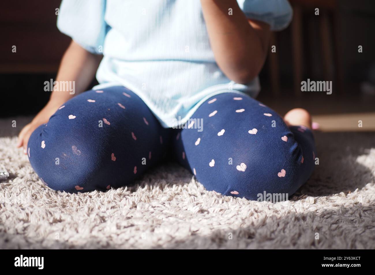 child sitting W posture on the floor Stock Photo - Alamy