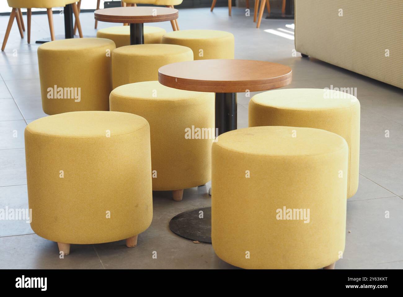 The modern yellow seating and table arrangement in a stylish cafe ...