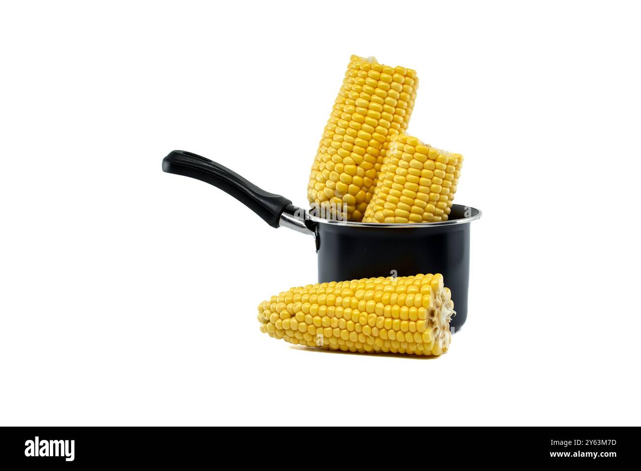 Fresh corn cobs arranged in a black saucepan with additional cobs ...