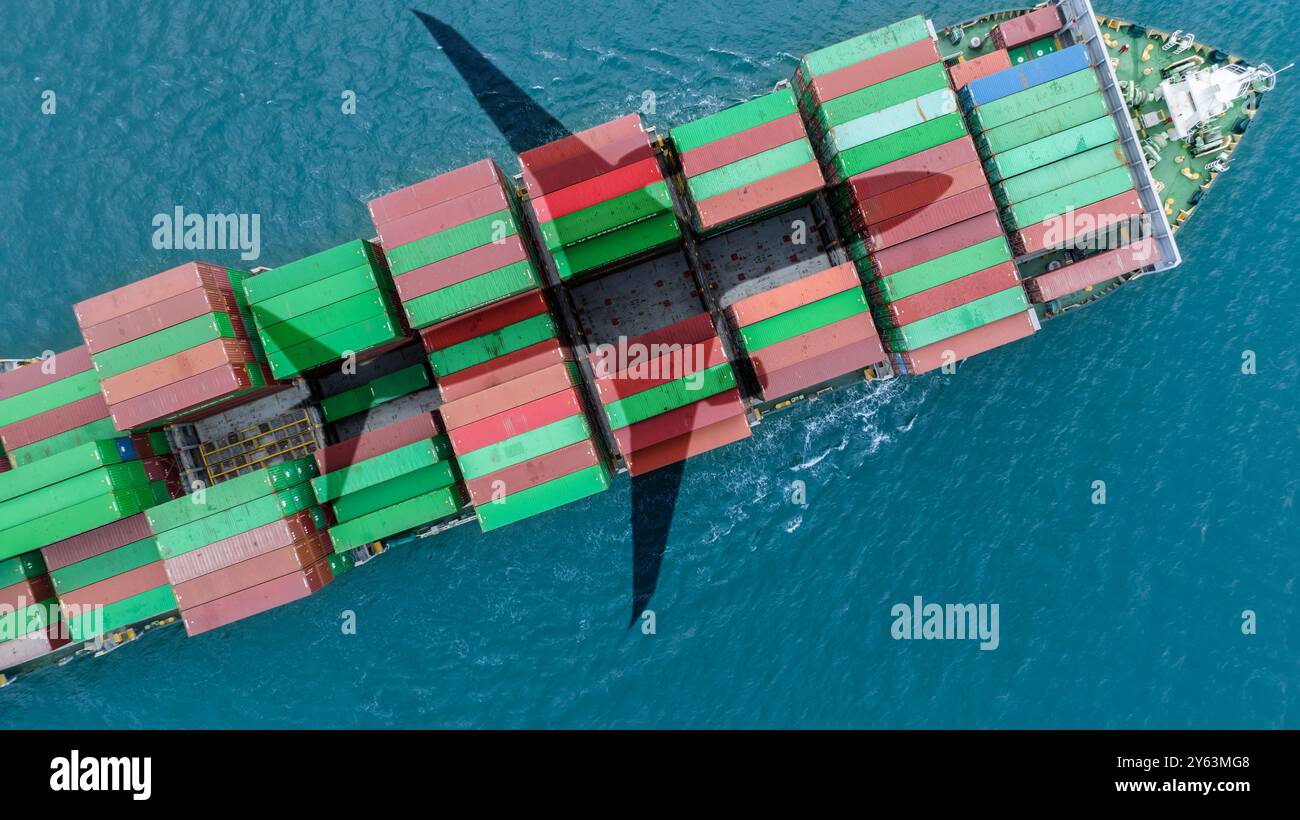 Aerial view container cargo ship at sea with airplane shadow. Global ...