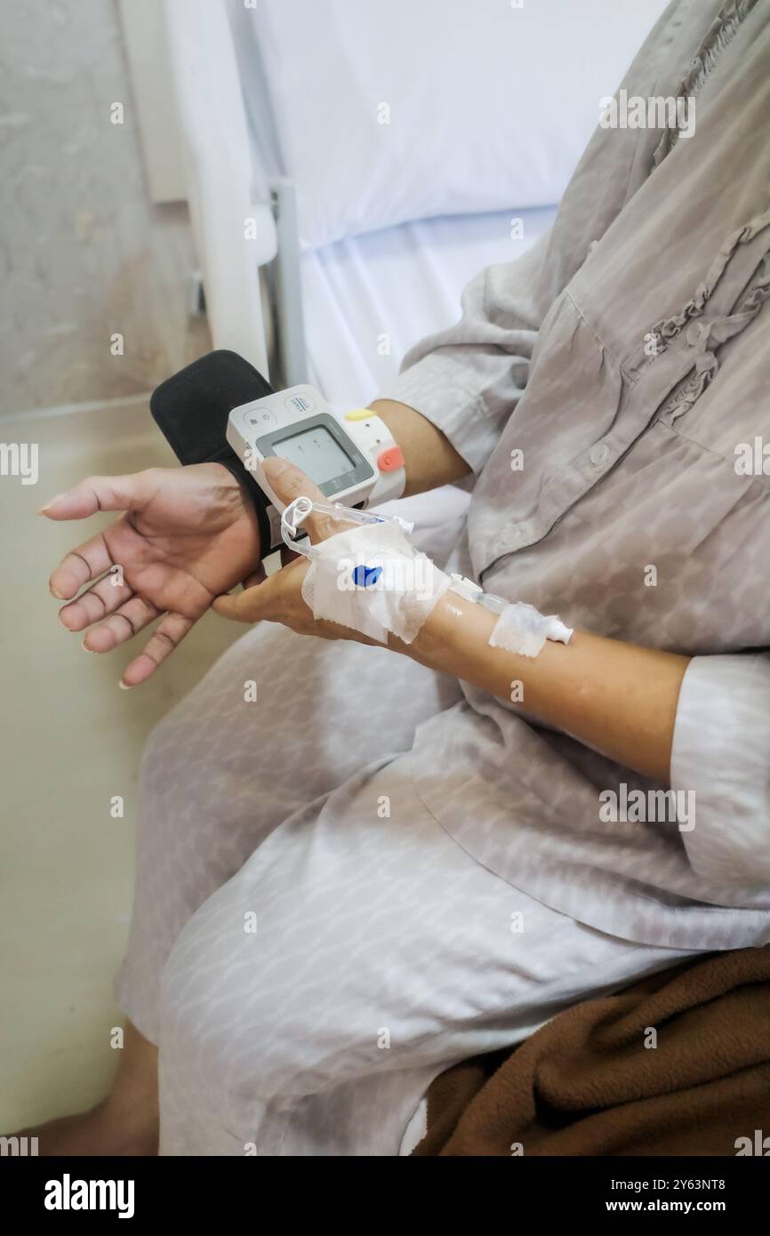 Mature adult female patient using digital blood pressure and heart rate ...