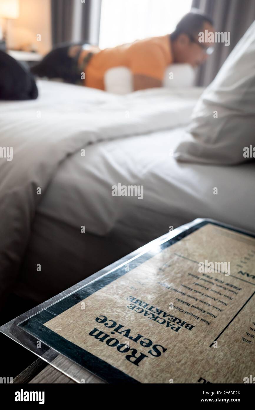 Room service menu at hotel room with guest laying on bed on the ...