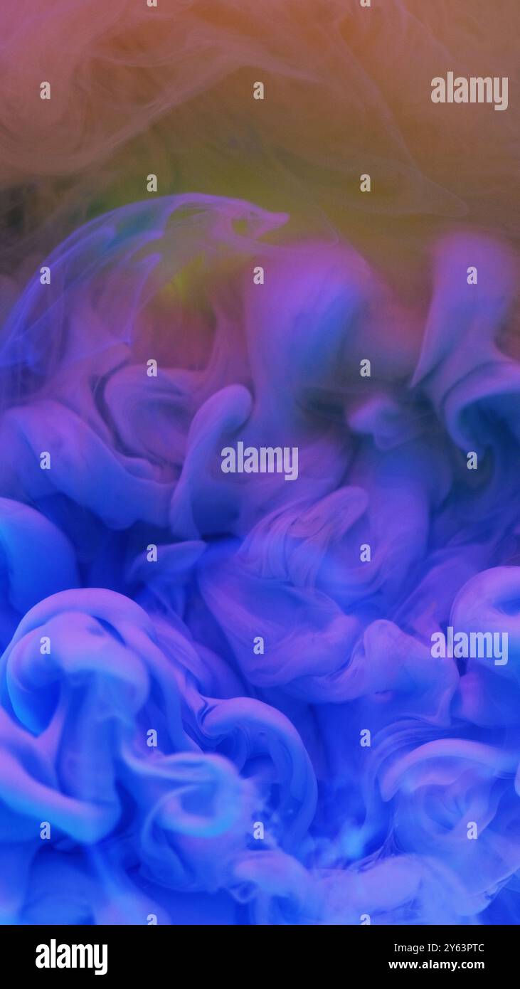 Ink drop water. Neon smoke cloud. Defocused blue pink yellow color ...