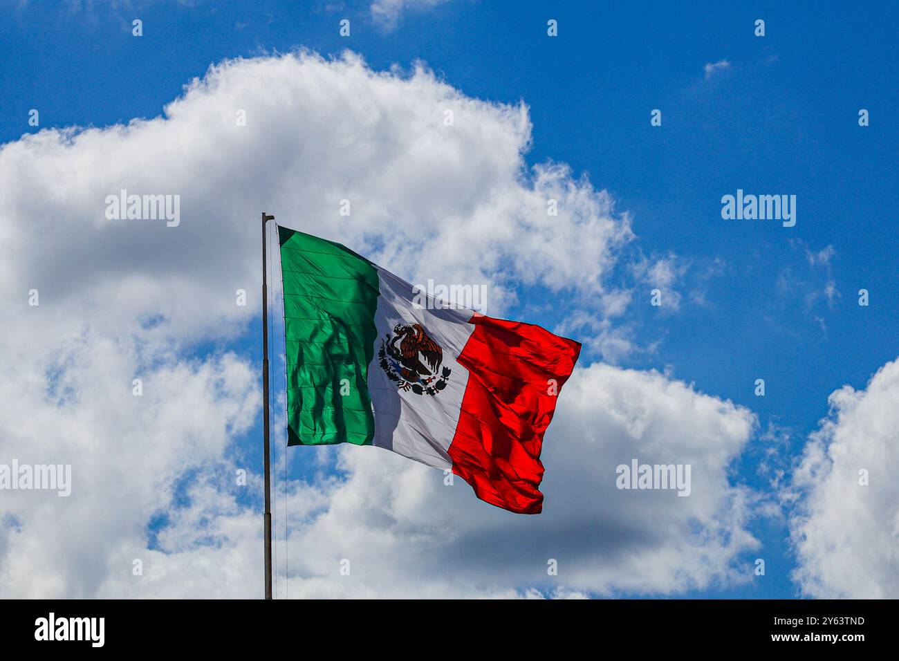 Mexican flag waving in the blue sky with clouds (Photo By Luis ...