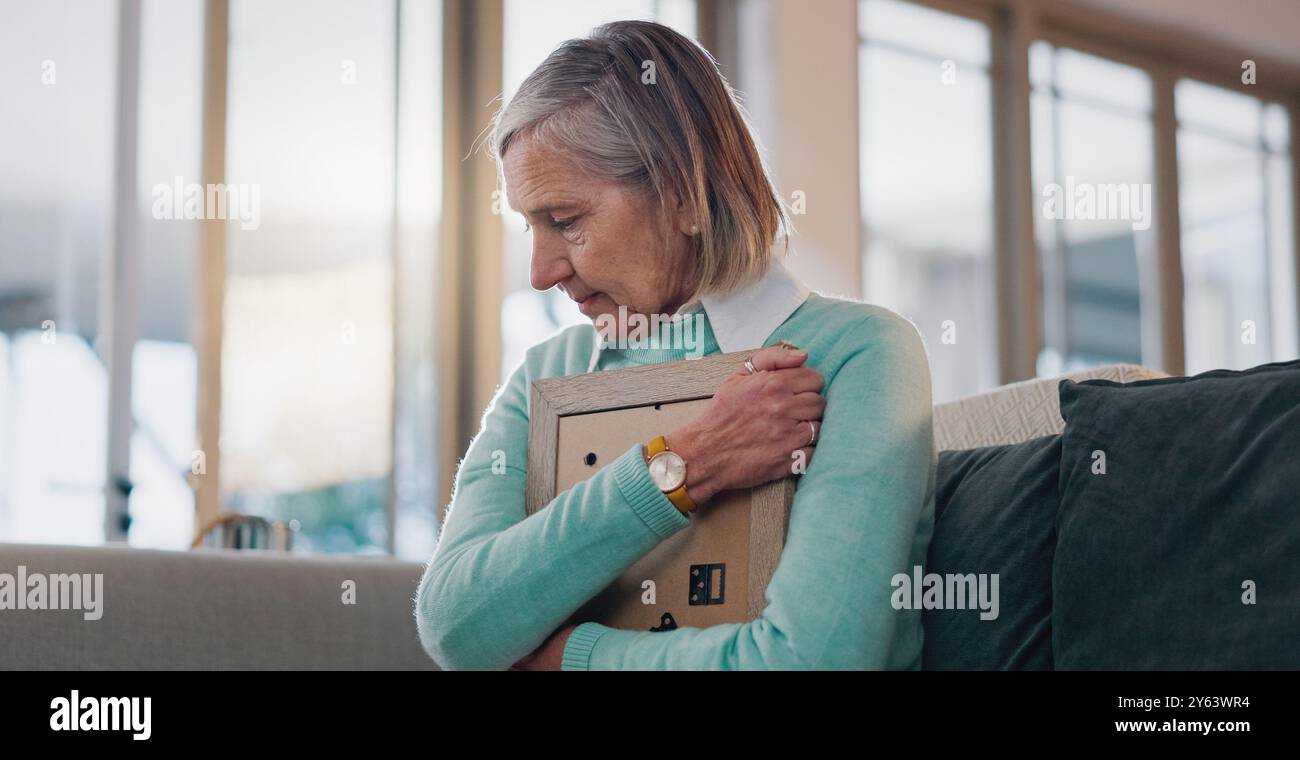 Crying, hug and senior woman with picture frame for mourning, loss or ...