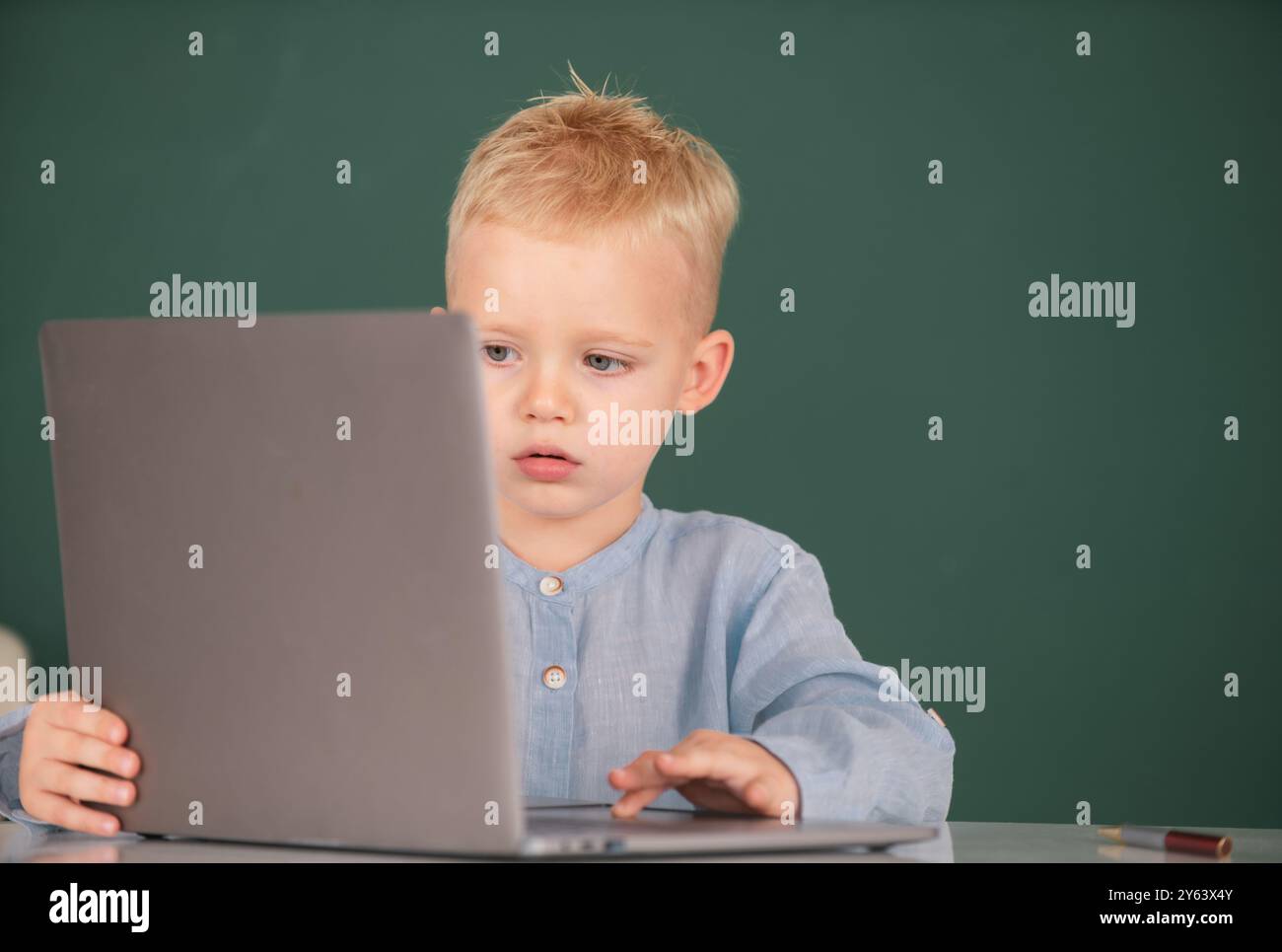 Elementary school kid working in computer class. Cute pupil face ...