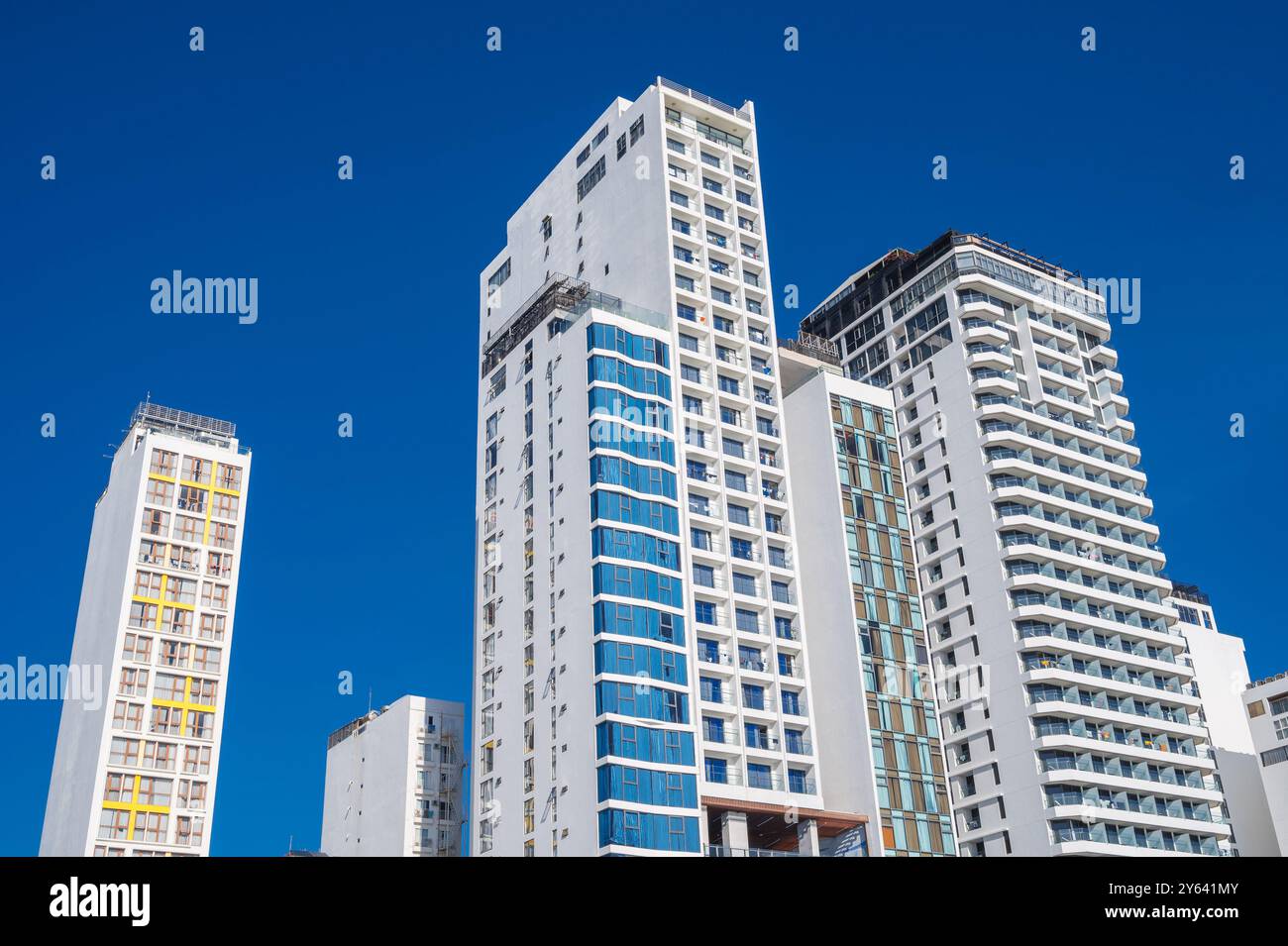 White facades of tall modern hotels and skyscrapers against the blue ...