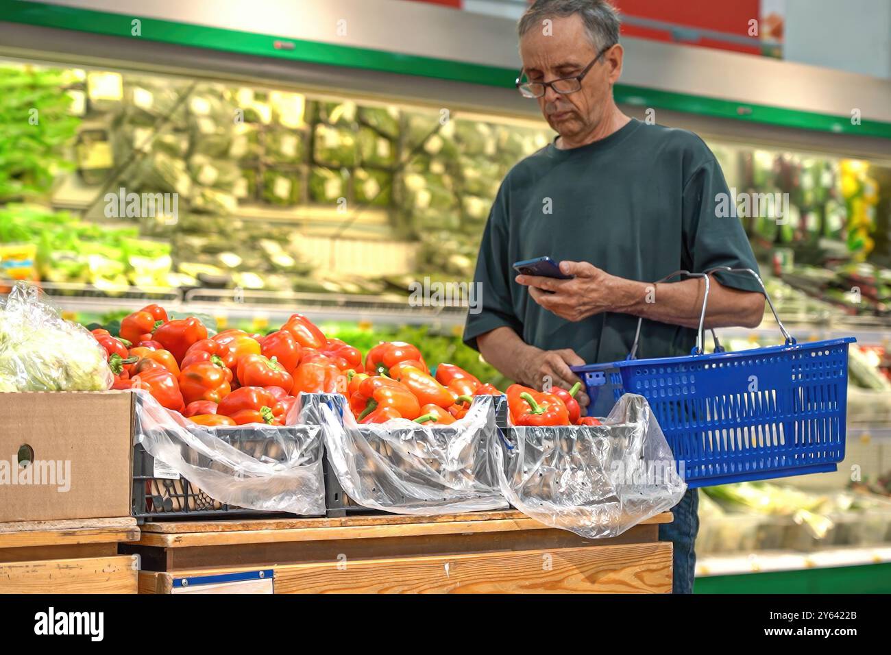 Mature man chooses yellow bell peppers in supermarket Stock Photo - Alamy