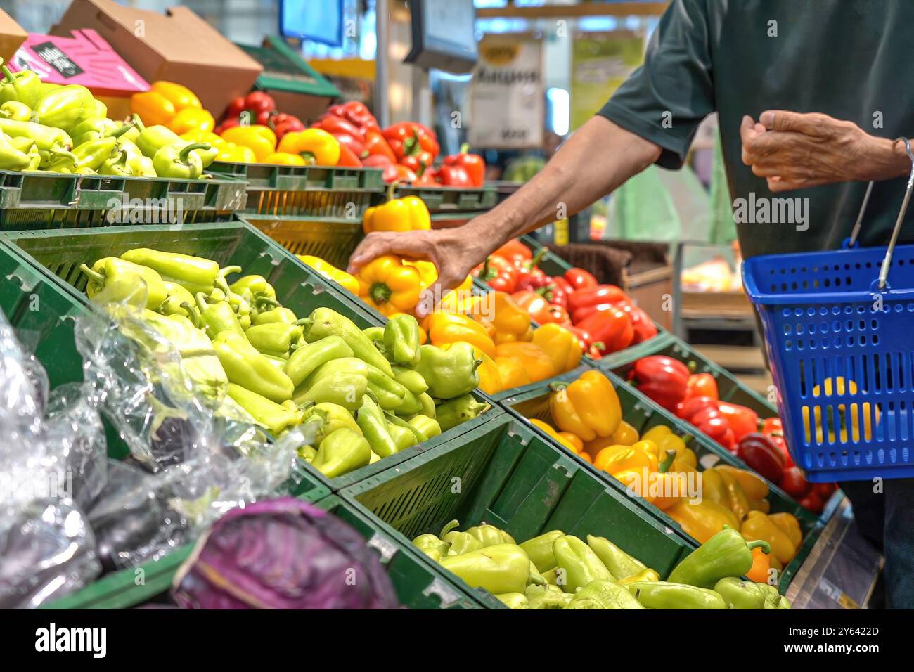 Mature man chooses yellow bell peppers in supermarket Stock Photo - Alamy