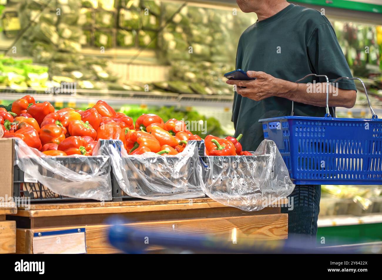 Mature man chooses yellow bell peppers in supermarket Stock Photo - Alamy