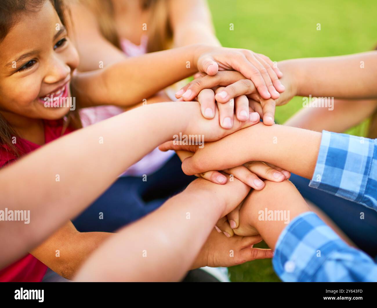 Happy, stack and hands of children in park for support, friendship and bonding outdoors ...