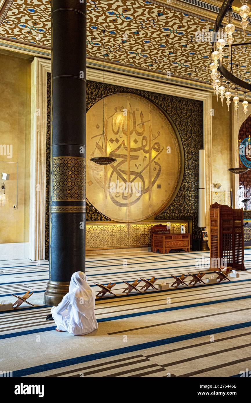 A man praying at the Katara Mosque (designed world famous Turkish ...