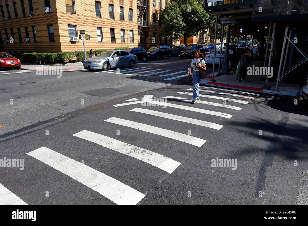 A person walks across a raised crosswalk in New York City. They are ...