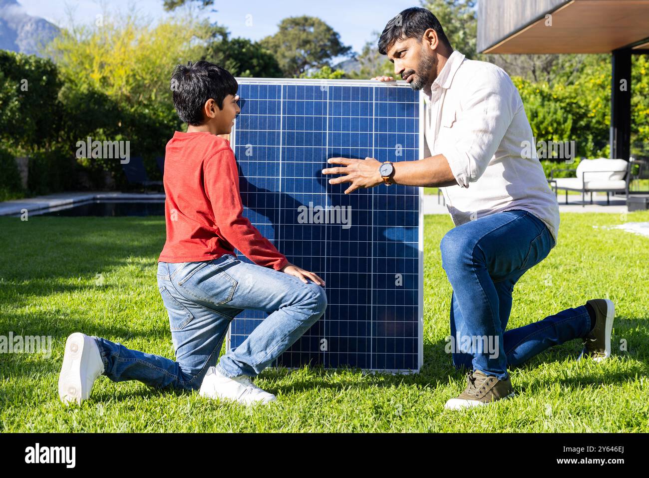 Installing solar panel in backyard, indian father and son learning ...