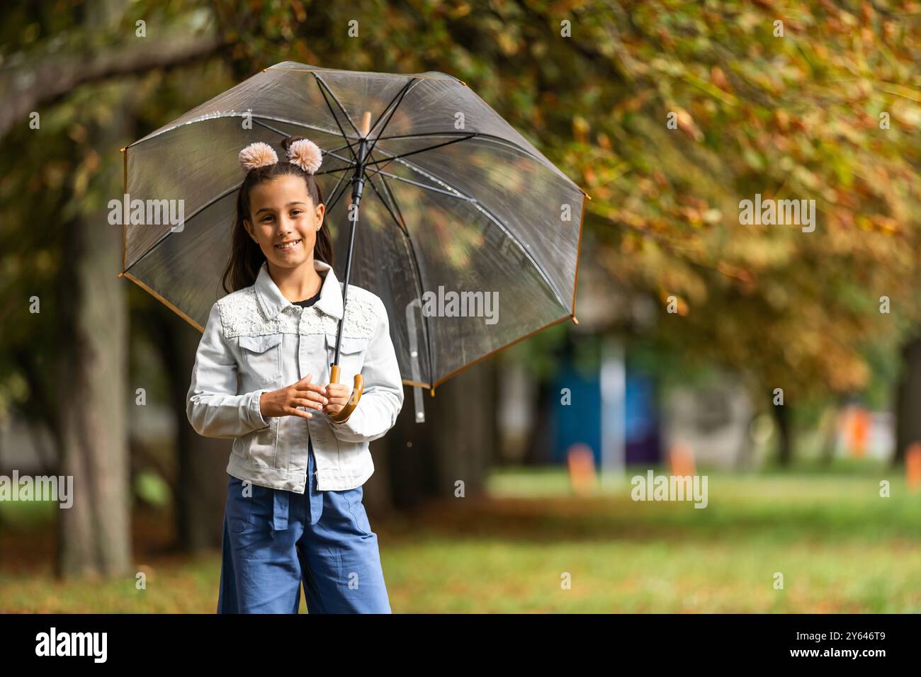 Kid playing out in the rain. Children with umbrella play outdoors in ...