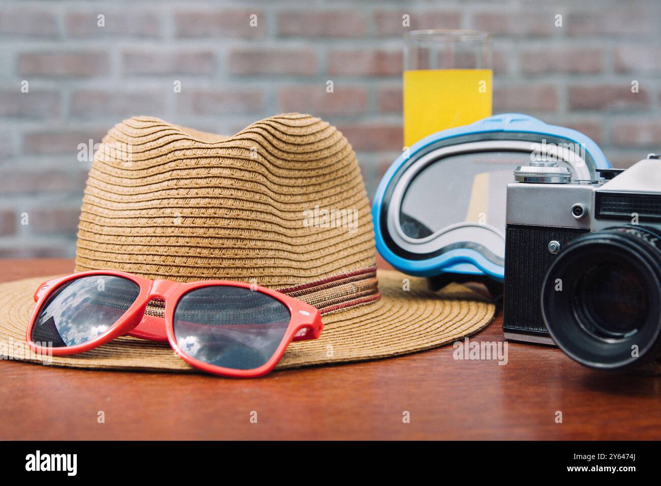 Tourist theme still life. Beach hat, scuba mask, camera, red sunglasses ...