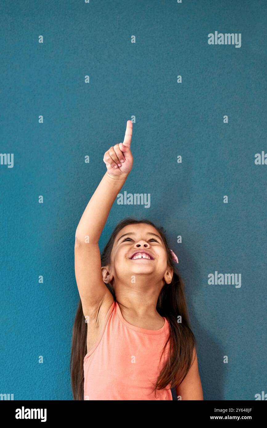 Pointing up, happy and child in studio with mockup space for omg news ...