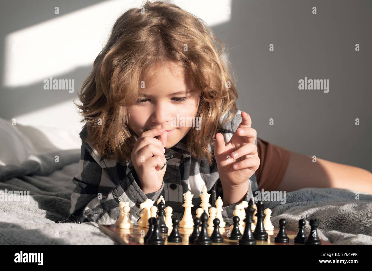 Little kid play chess. Thinking child. Chess game with children at home ...