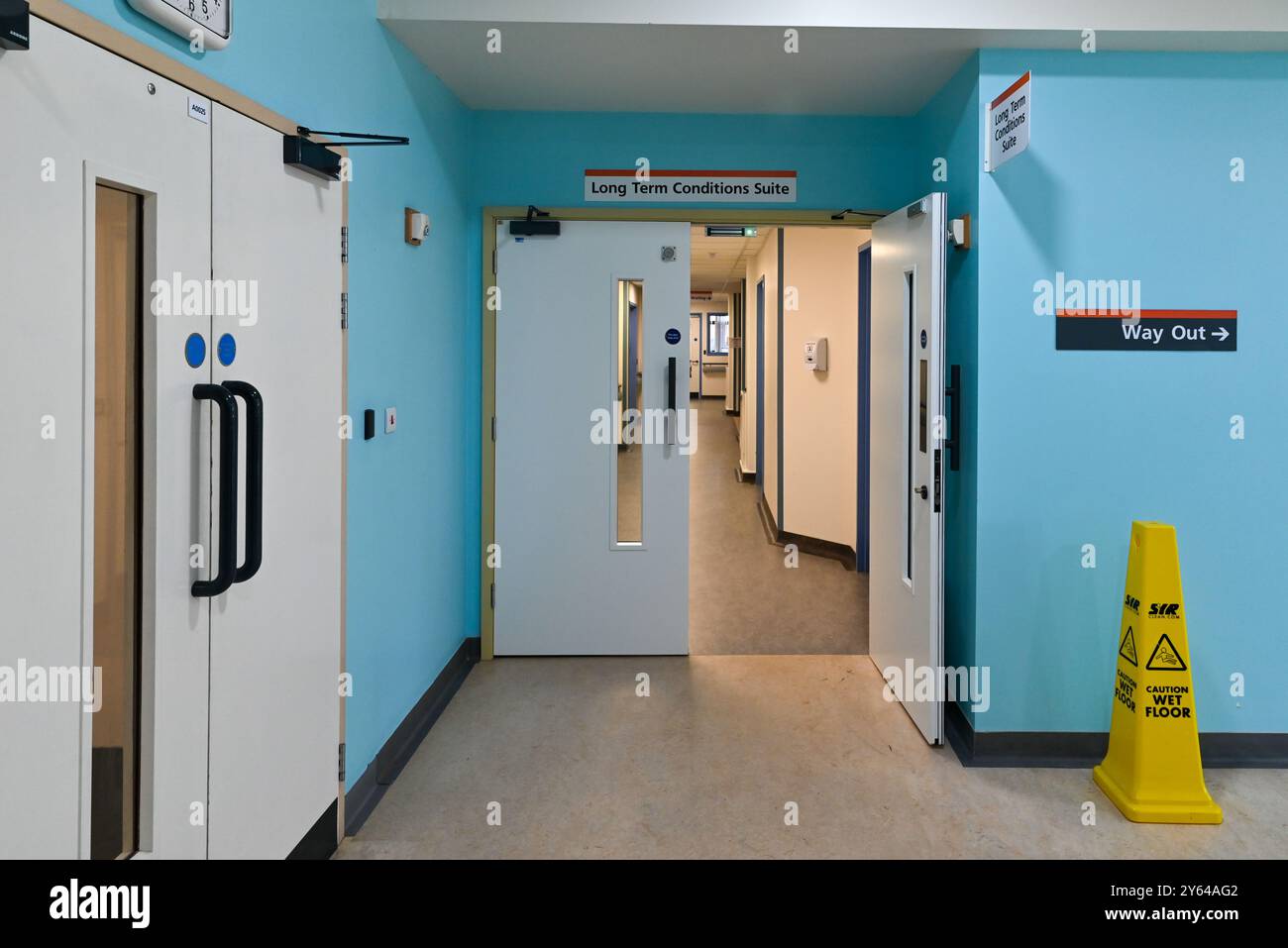 Empty corridor inside an NHS hospital with an open fire door. September ...