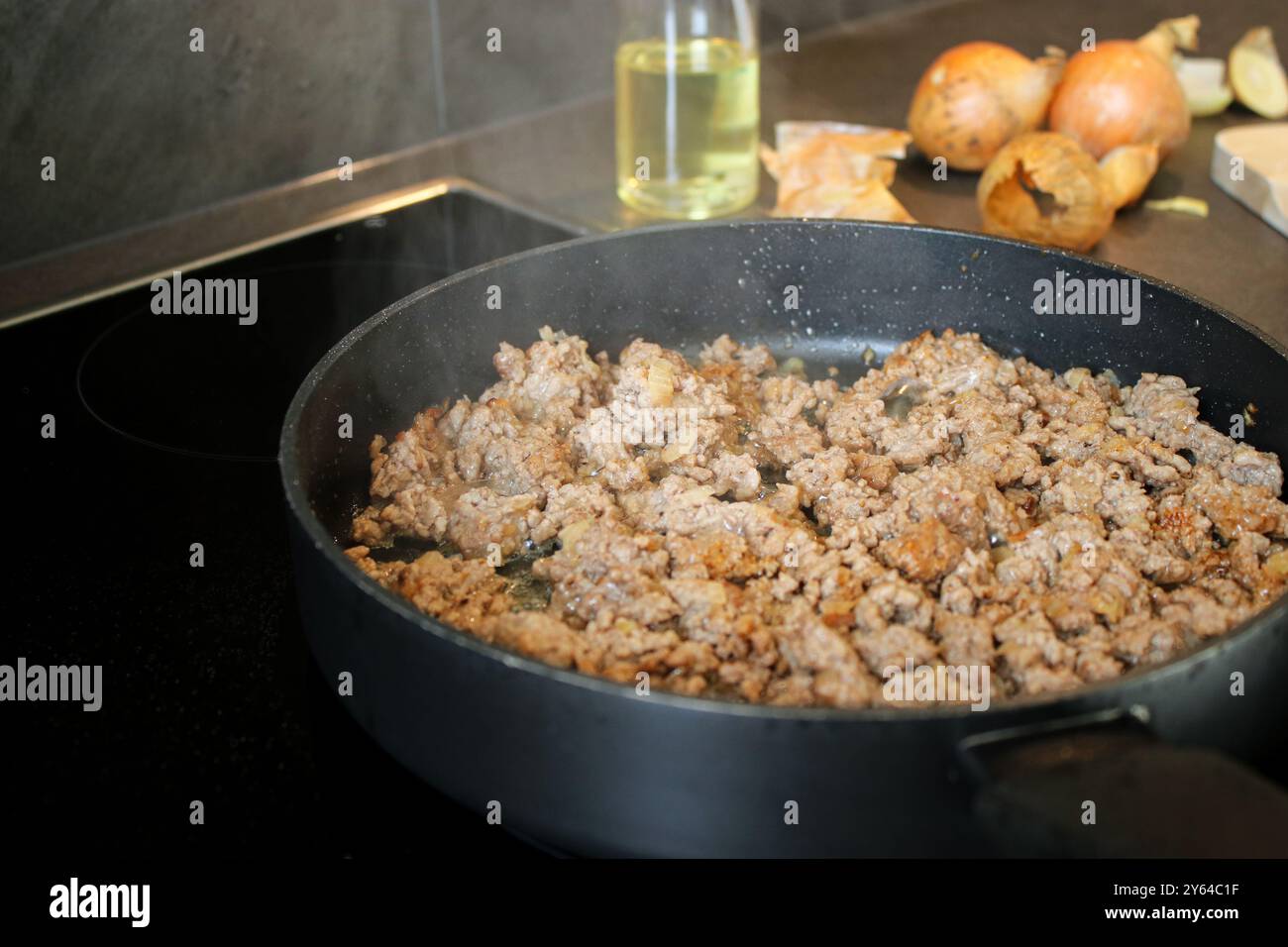 Close up cooked ground beef meat frying in a black pan in the kitchen ...