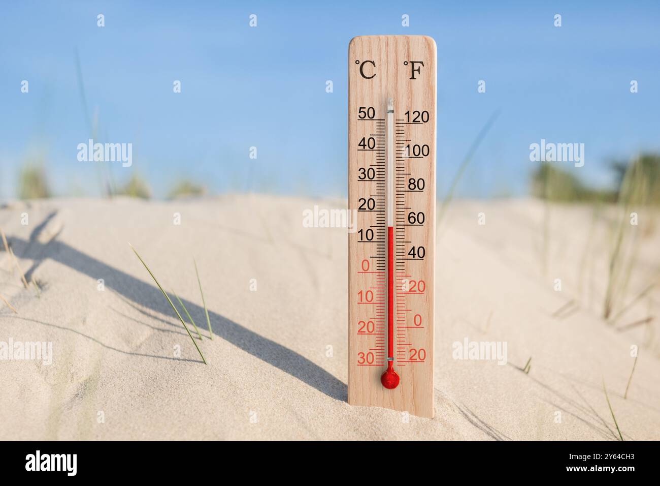 Wooden celsius and fahrenheit scale thermometer in the sand. Ambient ...