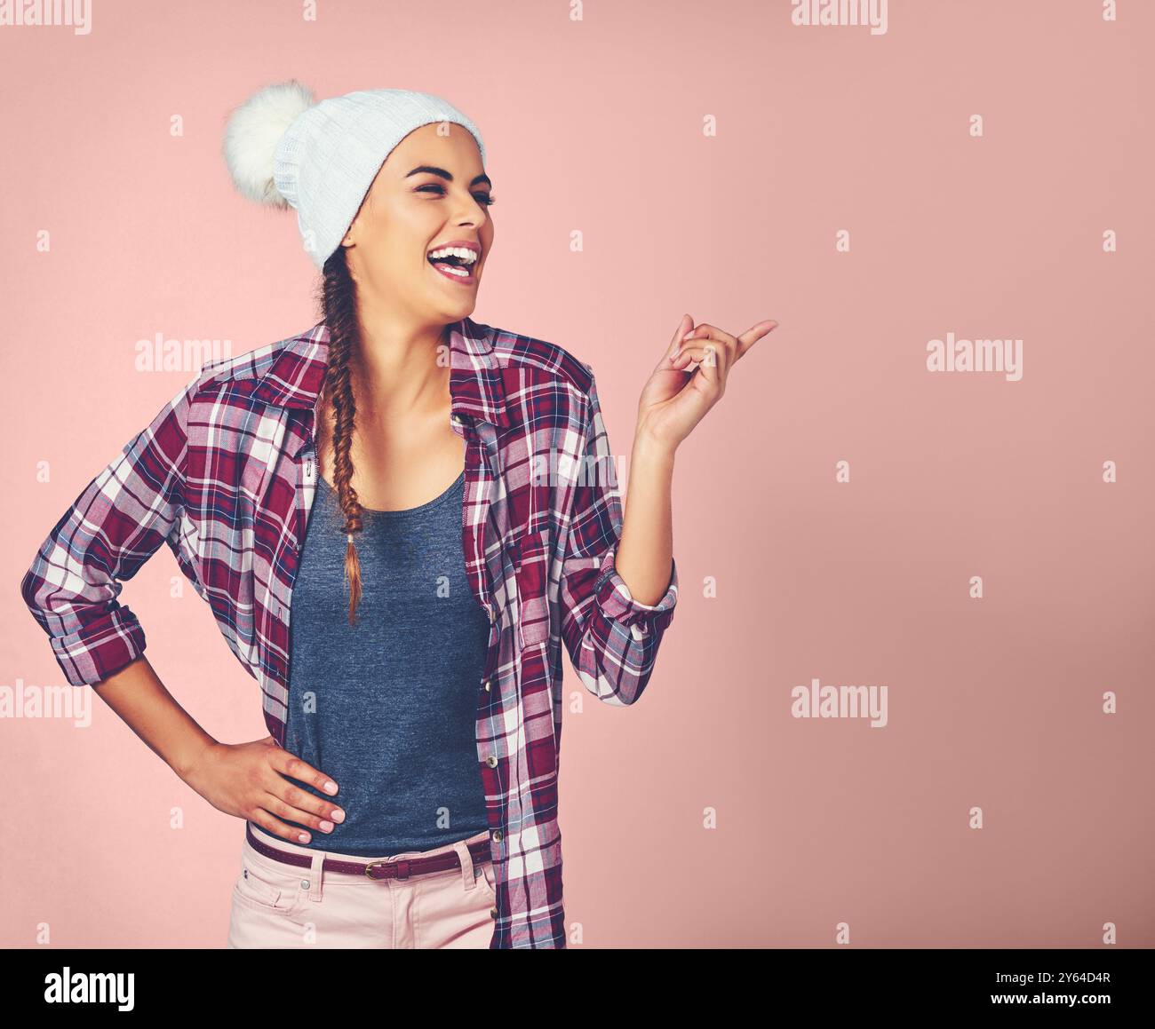 Woman, laughing and pointing in studio for joke, funny news and choice ...