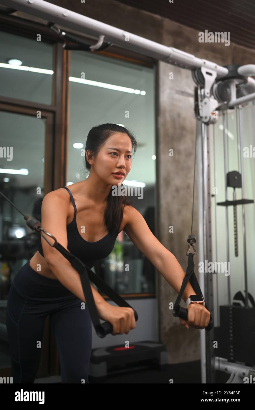 Young strong woman focusing on chest fly exercise in a gym. Sports and ...