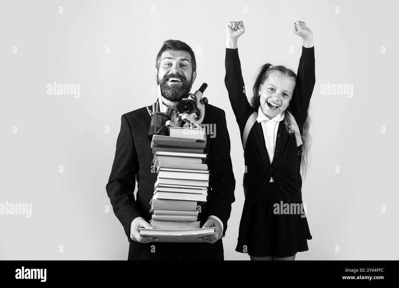 Cheerful smiling little girl in school uniform having fun in classroom ...