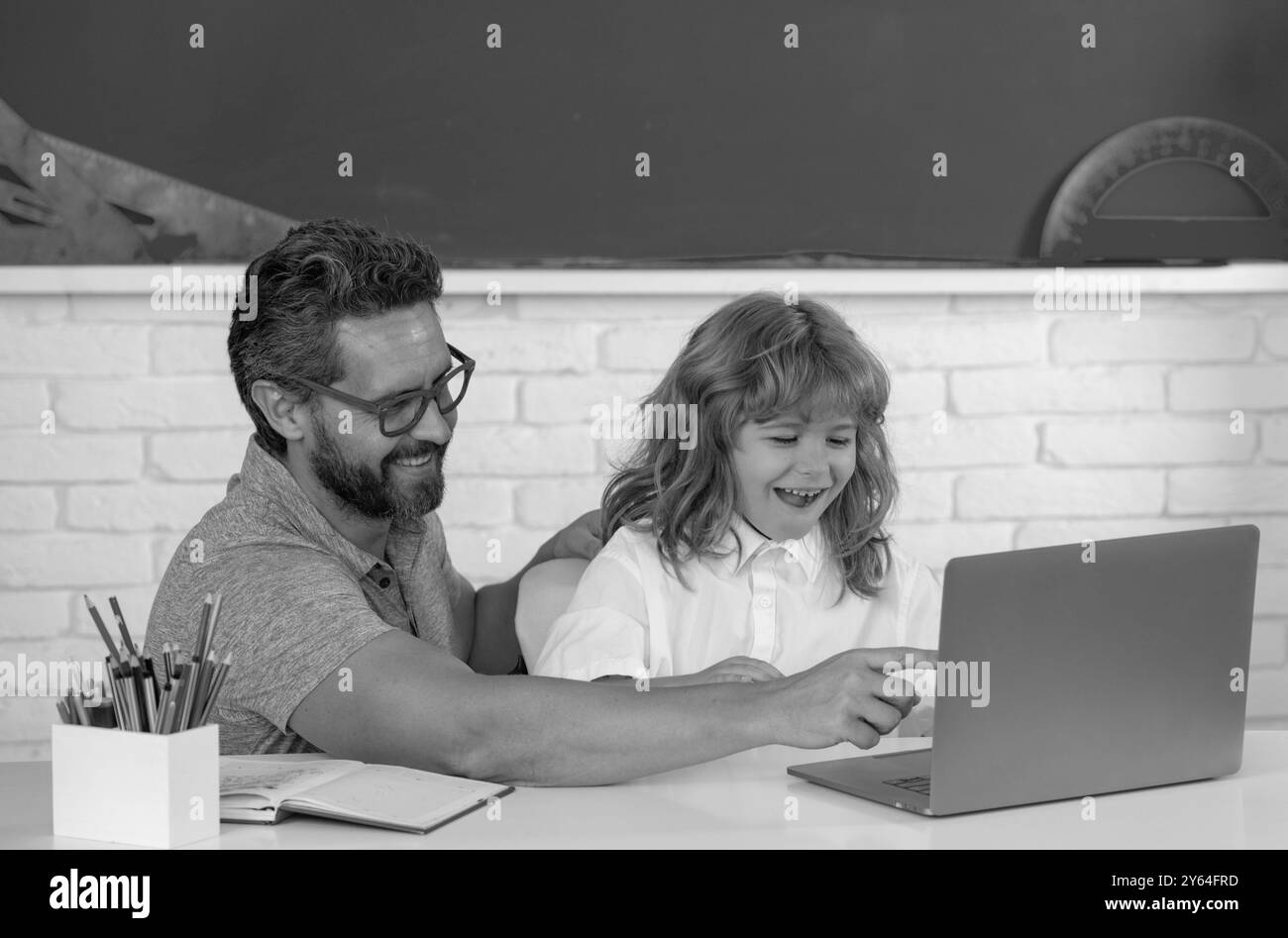 Back to school. Teacher and pupil boy learning at laptop computer ...