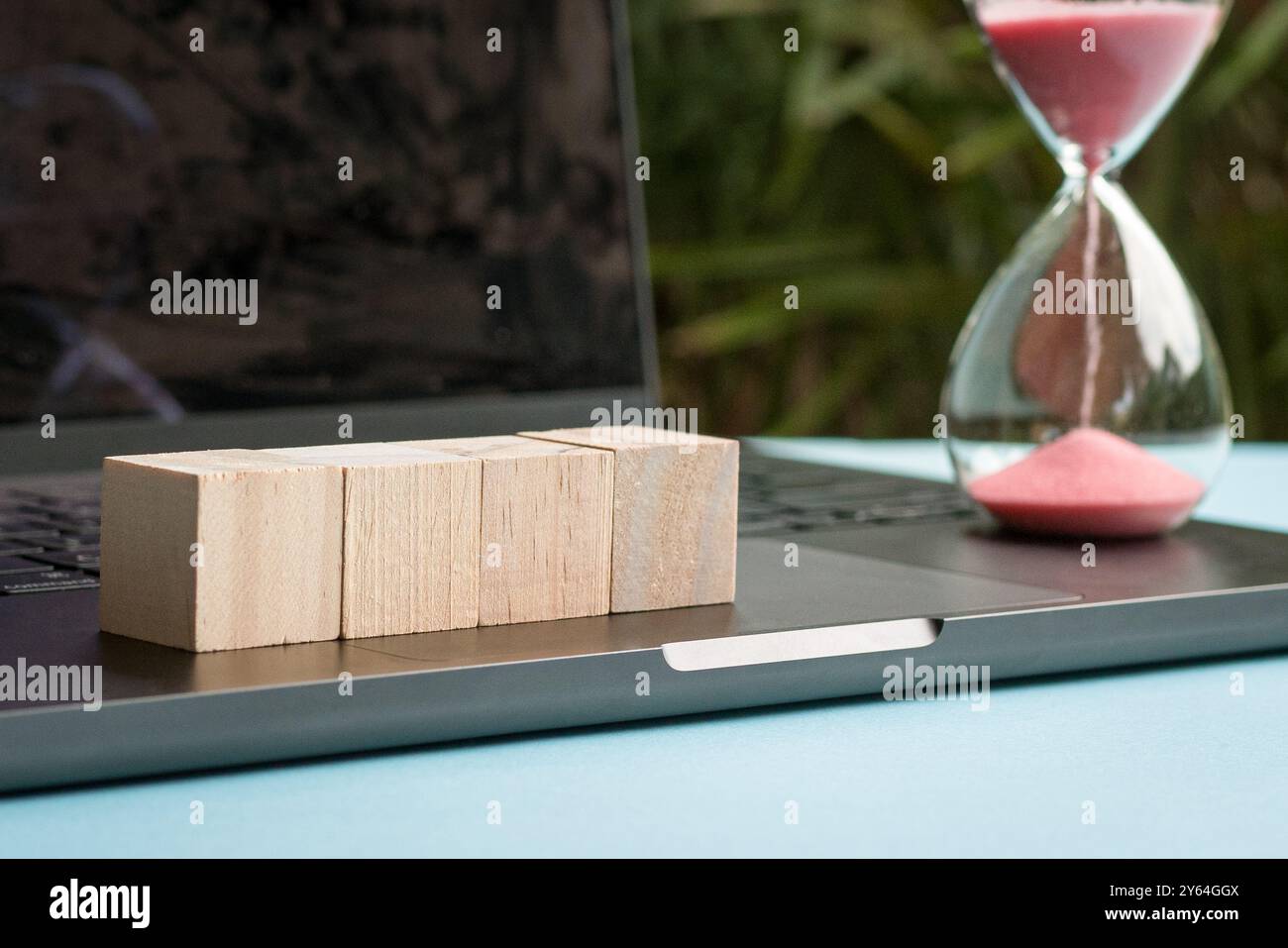 Four blank wood toy blocks in a row on top of computer laptop and next ...