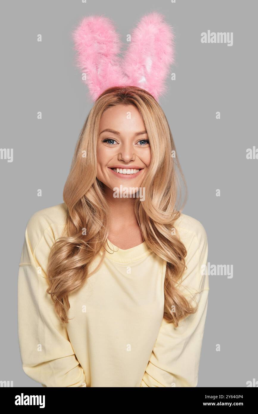 So cute! Attractive young woman in pink bunny ears smiling and looking ...